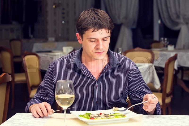 Young man having dinner in a restaurant | Stock image | Colourbox