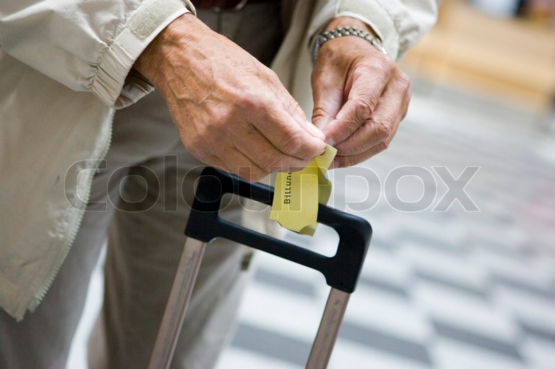 An elderly man putting a name tag on ... | Stock image | Colourbox