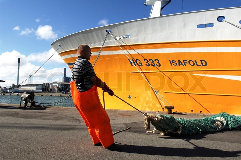 A worker pulling a fishing net on a ... | Stock Photo | Colourbox
