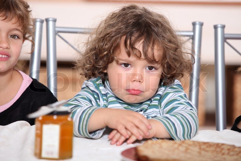 Grumpy toddler waiting to eat pancakes | Stock image | Colourbox